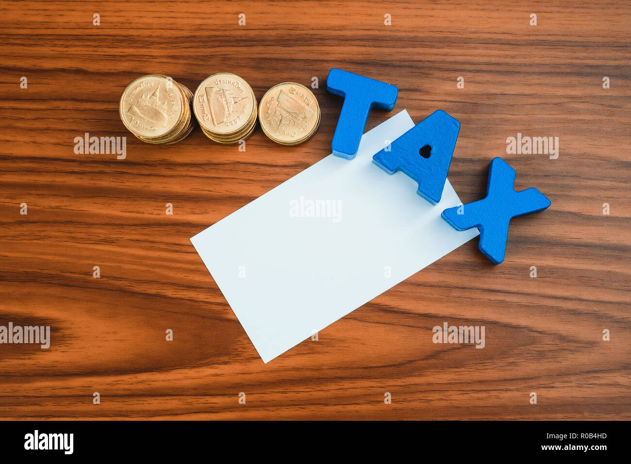 TAX concept. TAX alphabet with stack of coin and business card or name ...