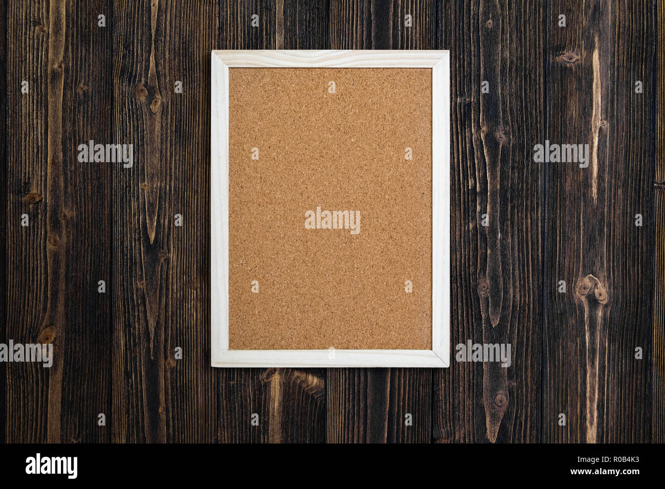 Empty cork board with wooden frame on wooden desk, top view with copy ...