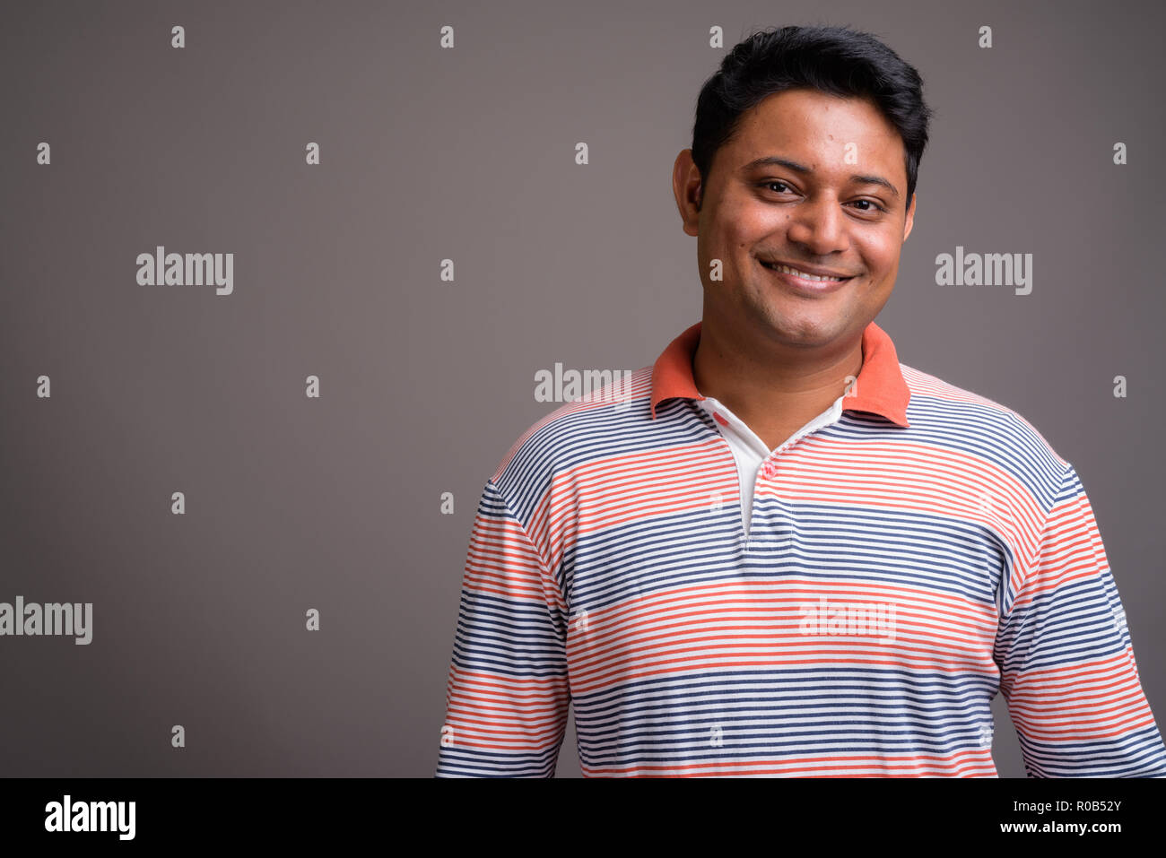 Portrait of young Indian man against gray background Stock Photo - Alamy