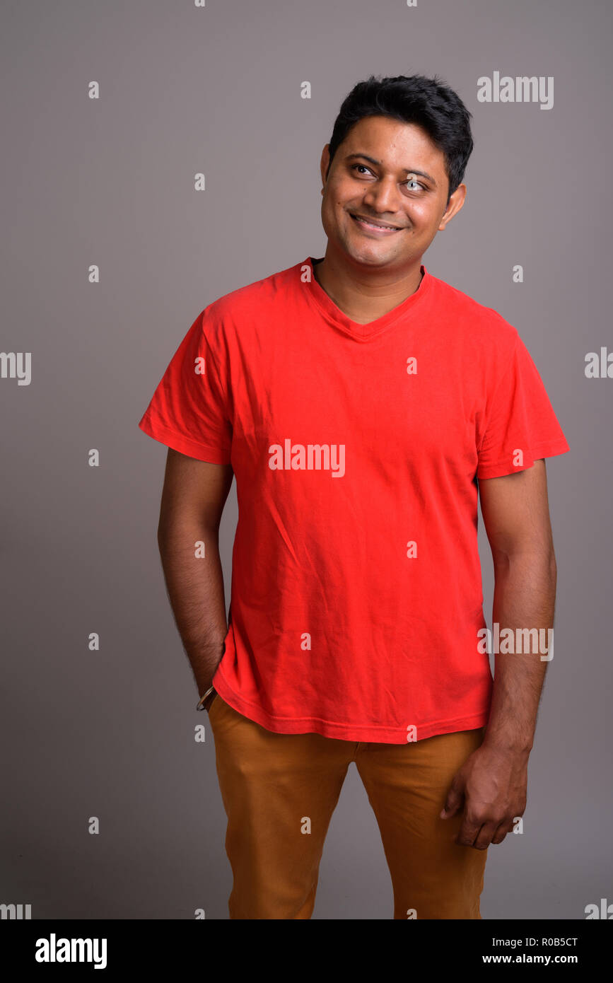Portrait of young Indian man against gray background Stock Photo - Alamy