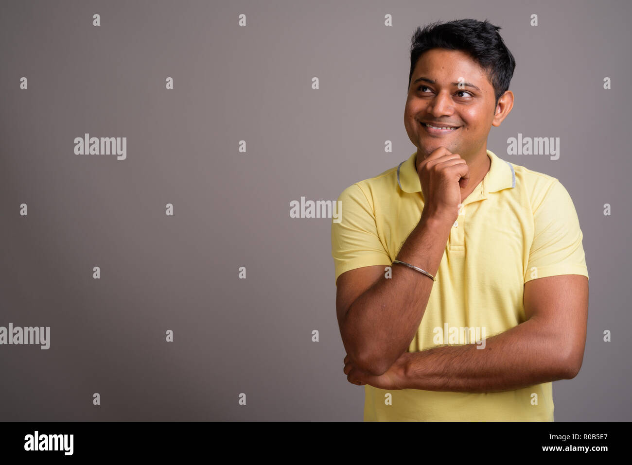 Portrait of young Indian man against gray background Stock Photo - Alamy
