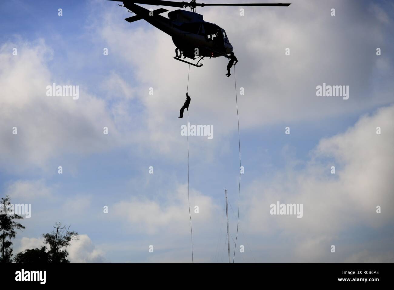 silhouette Soldier rappelling from helicopter in blue sky Stock Photo ...