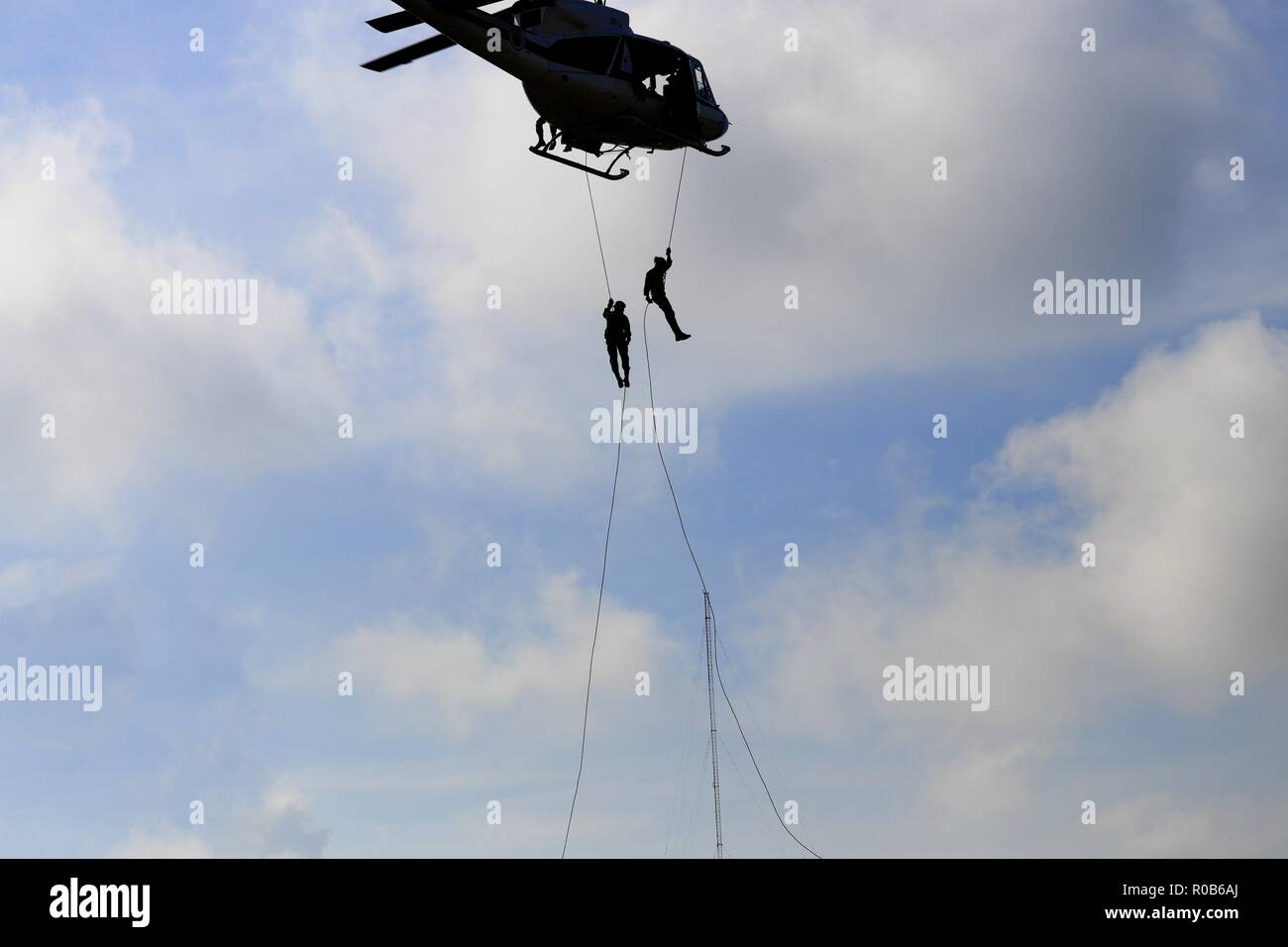 silhouette Soldier rappelling from helicopter in blue sky Stock Photo ...