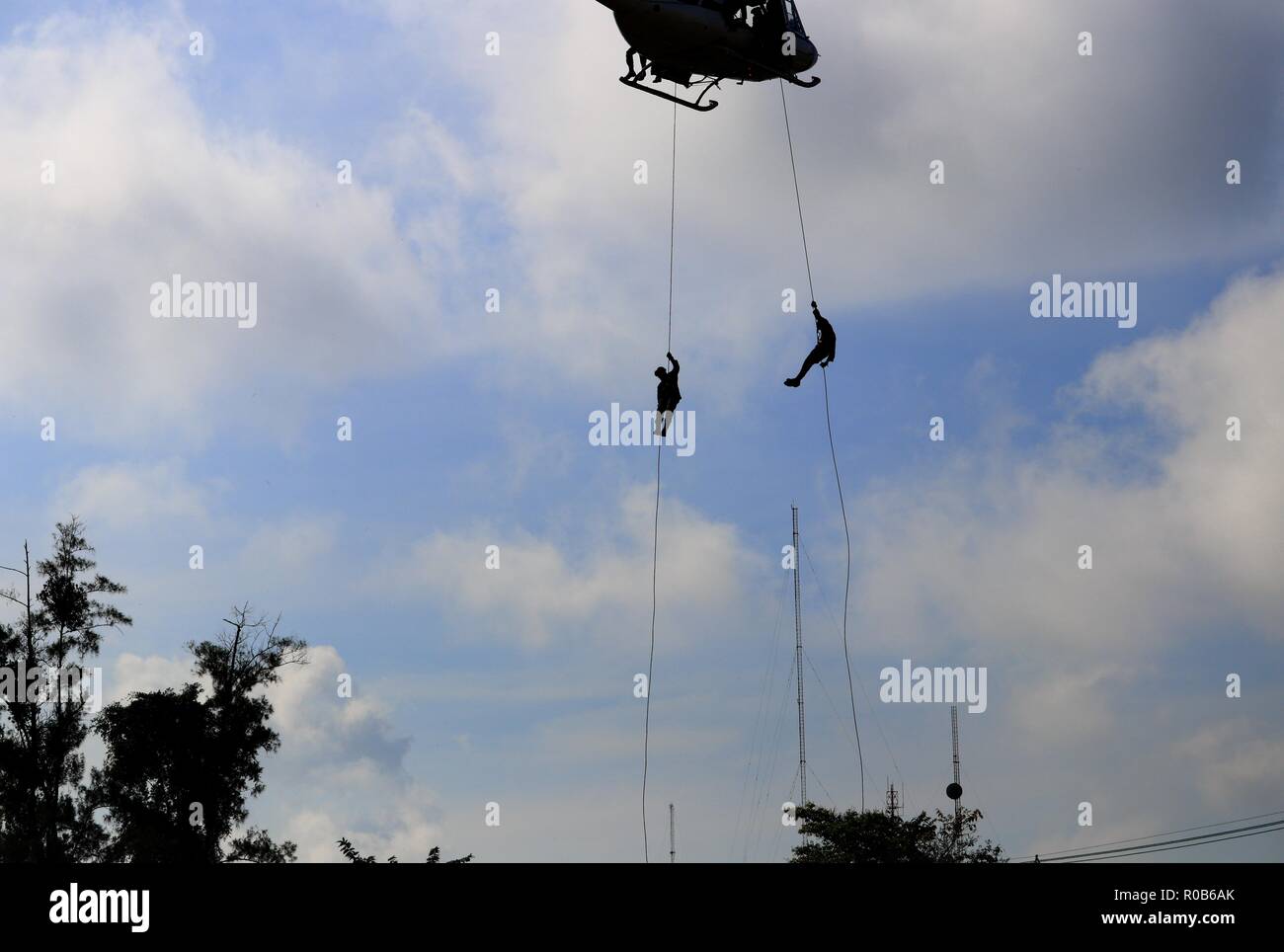 silhouette Soldier rappelling from helicopter in blue sky Stock Photo ...