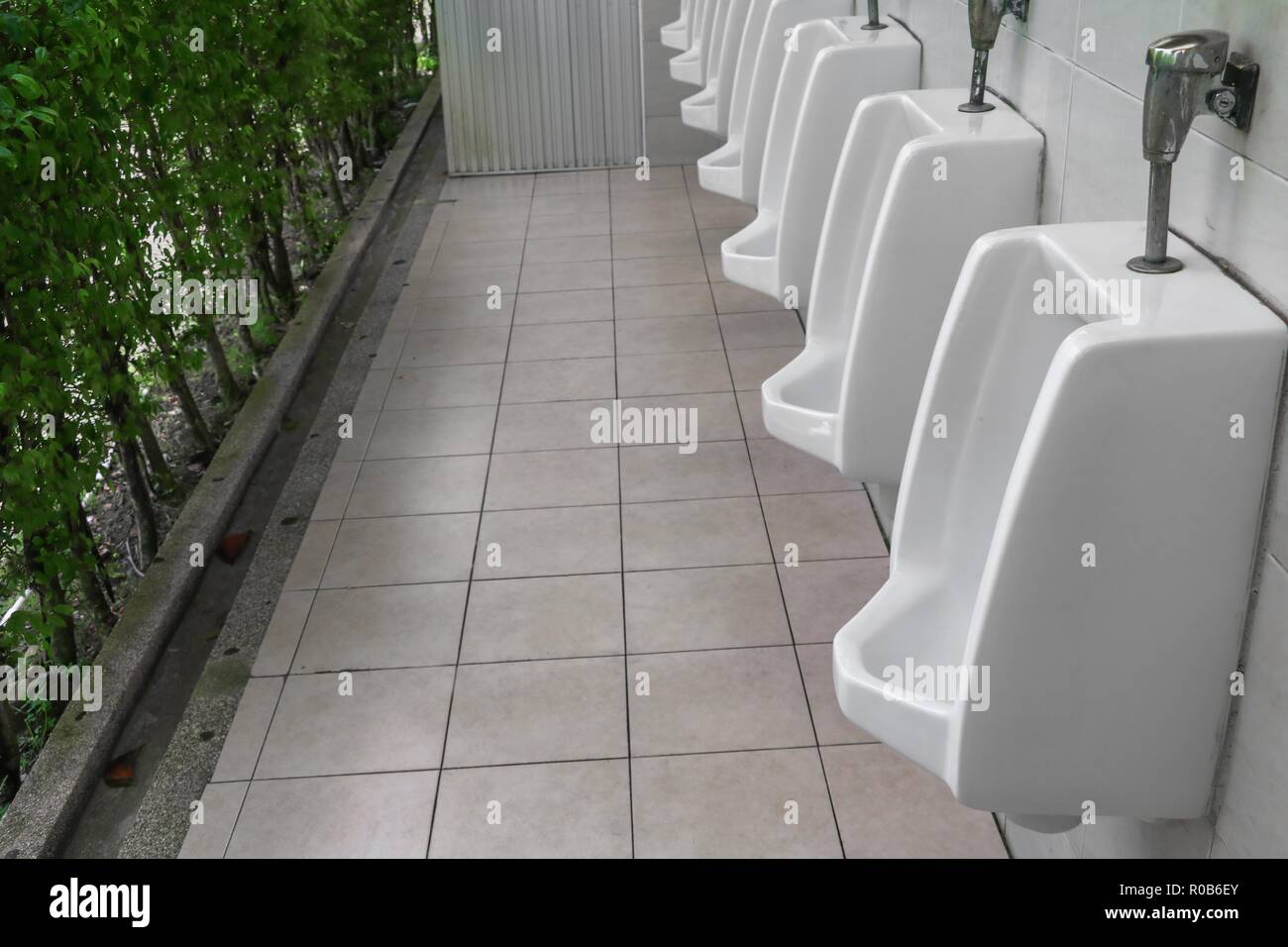 row of outdoor urinal men public toilet white urinals in men bathroom ...