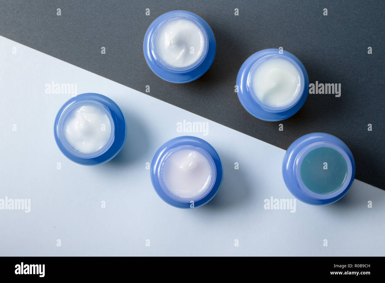 A set of five blue jars with moisturizers for day and night use. Men's ...