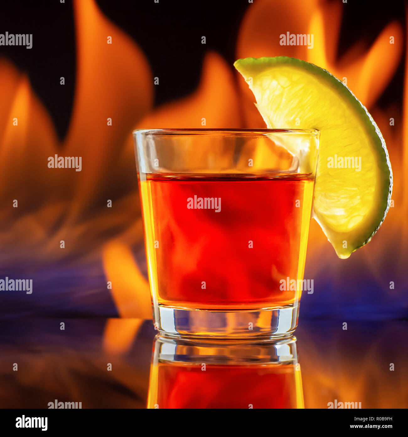 tequila shot with slice of lime on fire background. Concept of strong ...