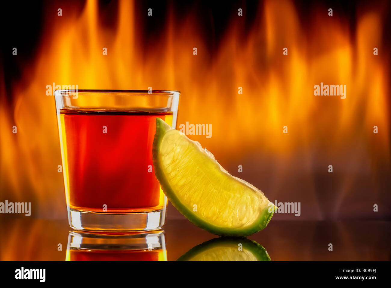 tequila shot with slice of lime on fire background. Concept of strong ...