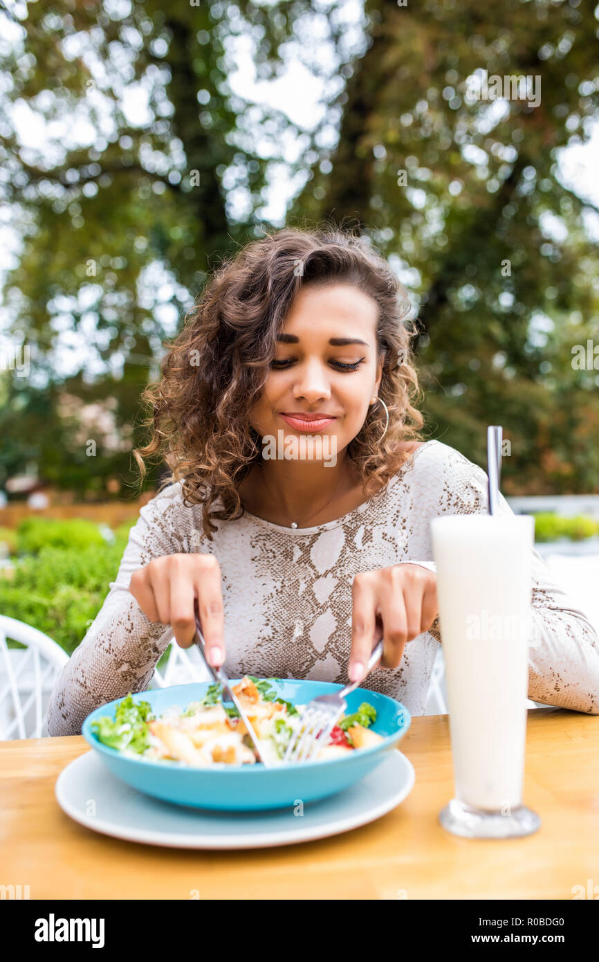 A beautiful woman has breakfast in a stylish cafe, a healthy breakfast ...