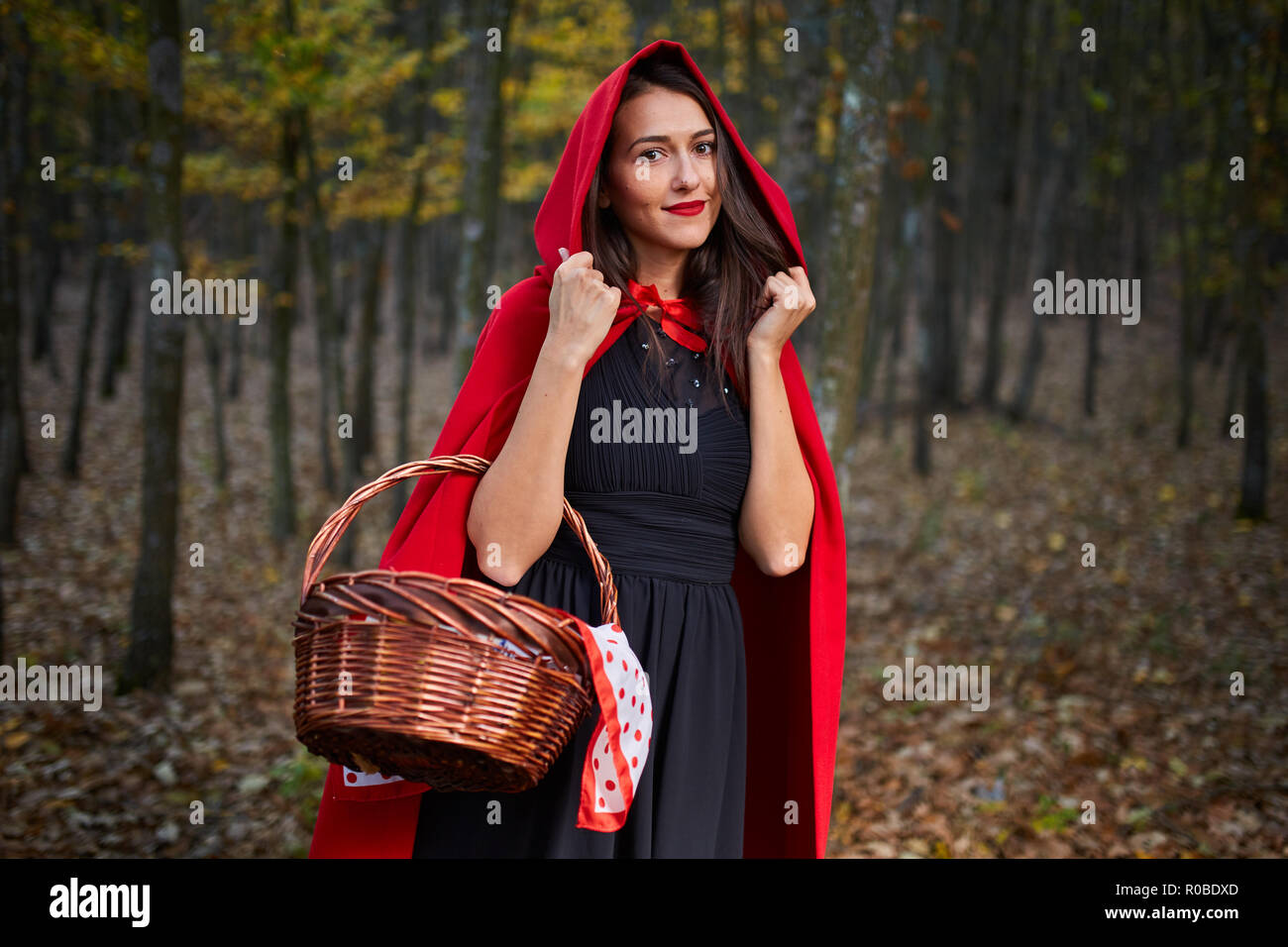 Woman dressed as Red Riding Hood in various postures in the forest ...
