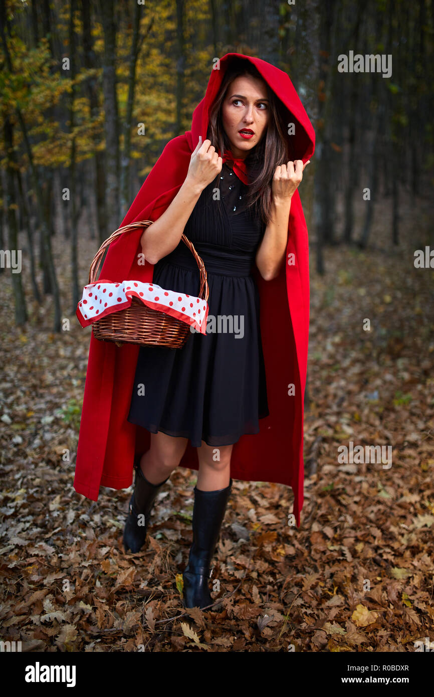 Woman dressed as Red Riding Hood in various postures in the forest ...
