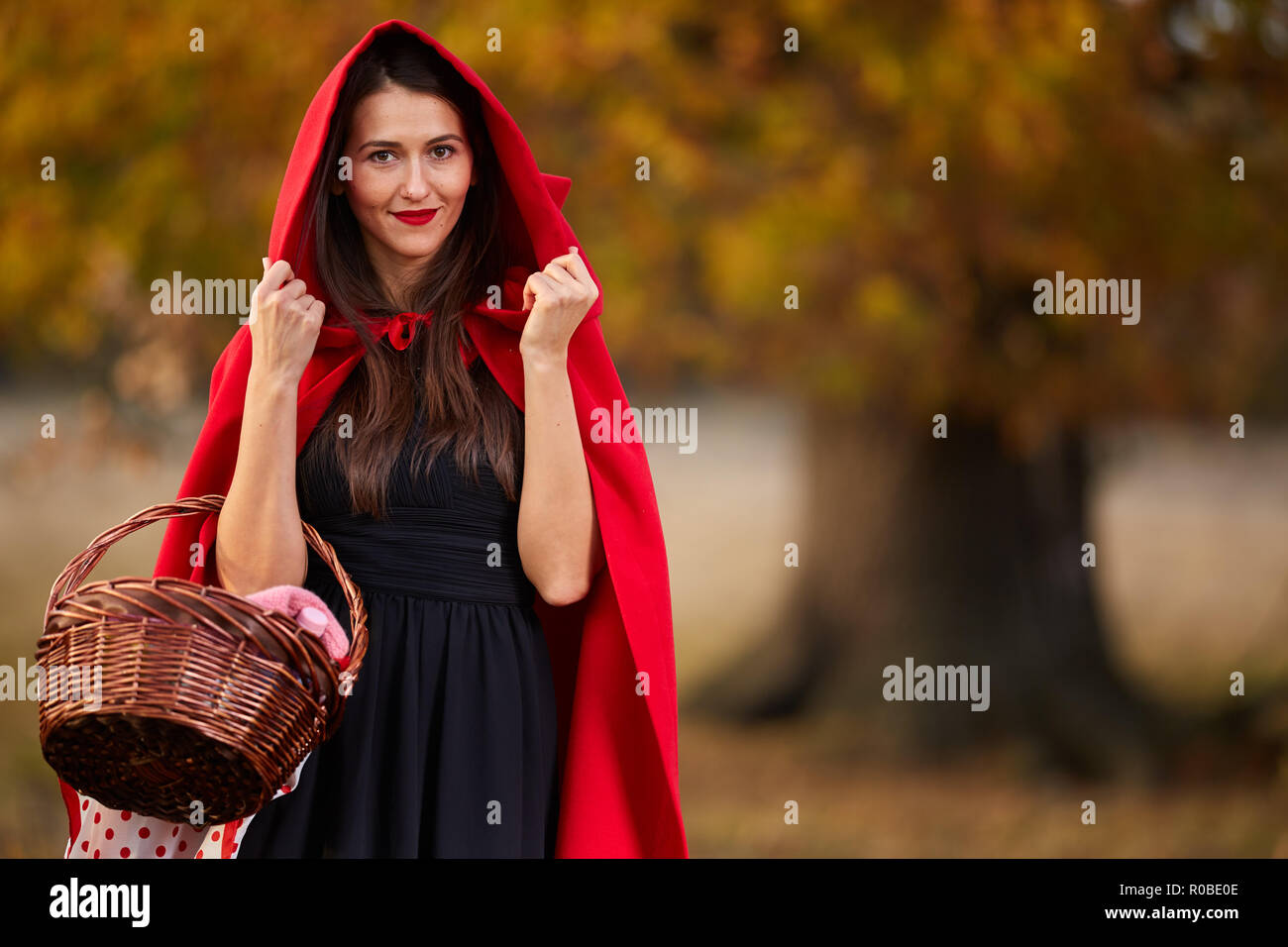 Woman dressed as Red Riding Hood in various postures in the forest ...