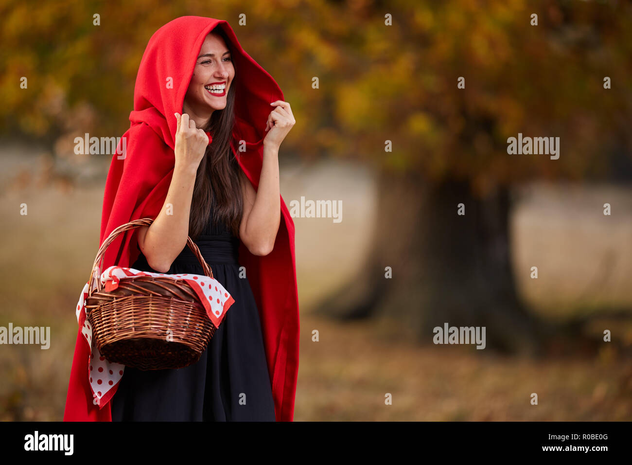 Woman dressed as Red Riding Hood in various postures in the forest ...
