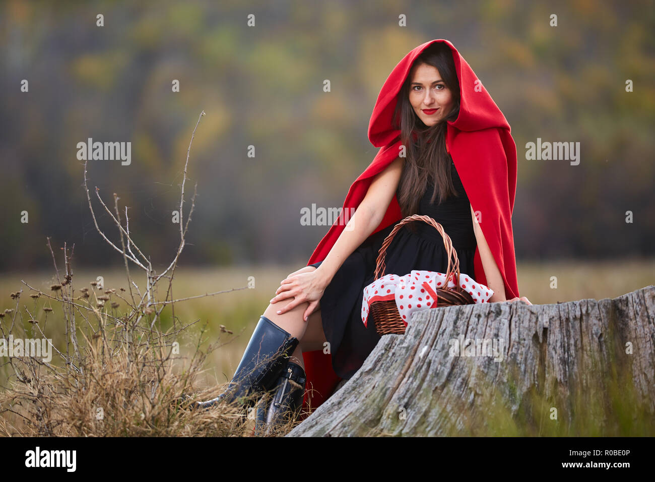 Woman dressed as Red Riding Hood in various postures in the forest ...