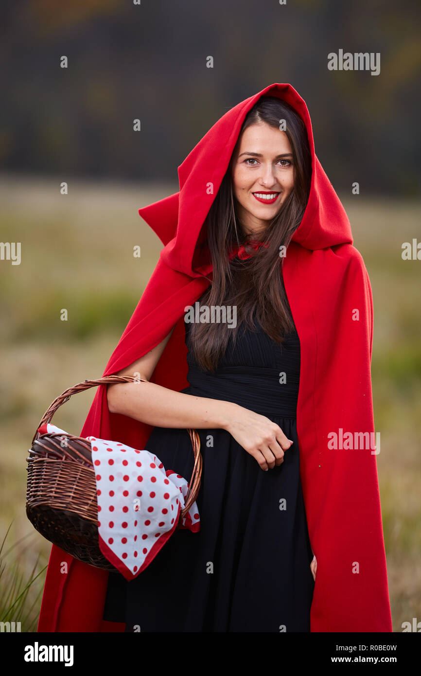 Woman dressed as Red Riding Hood in various postures in the forest ...