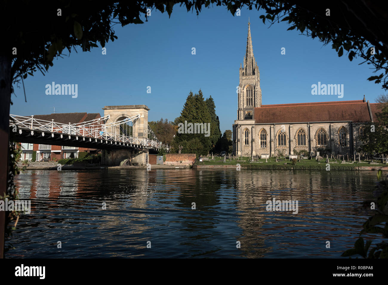 All Saints Church and the suspension bride on the river Thames at ...