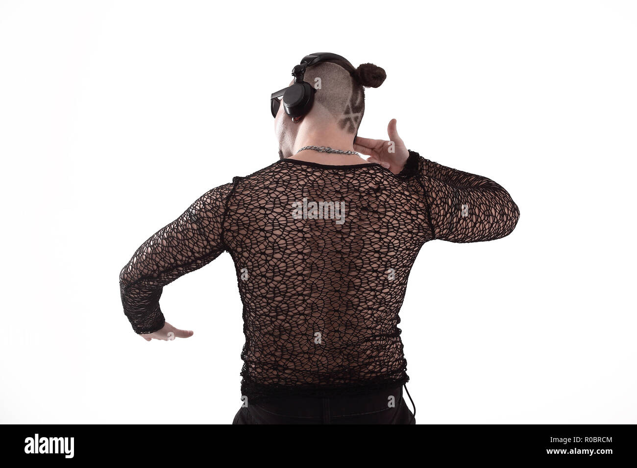 rear view .the guy rapper with a cool hair listens to music.isolated on ...