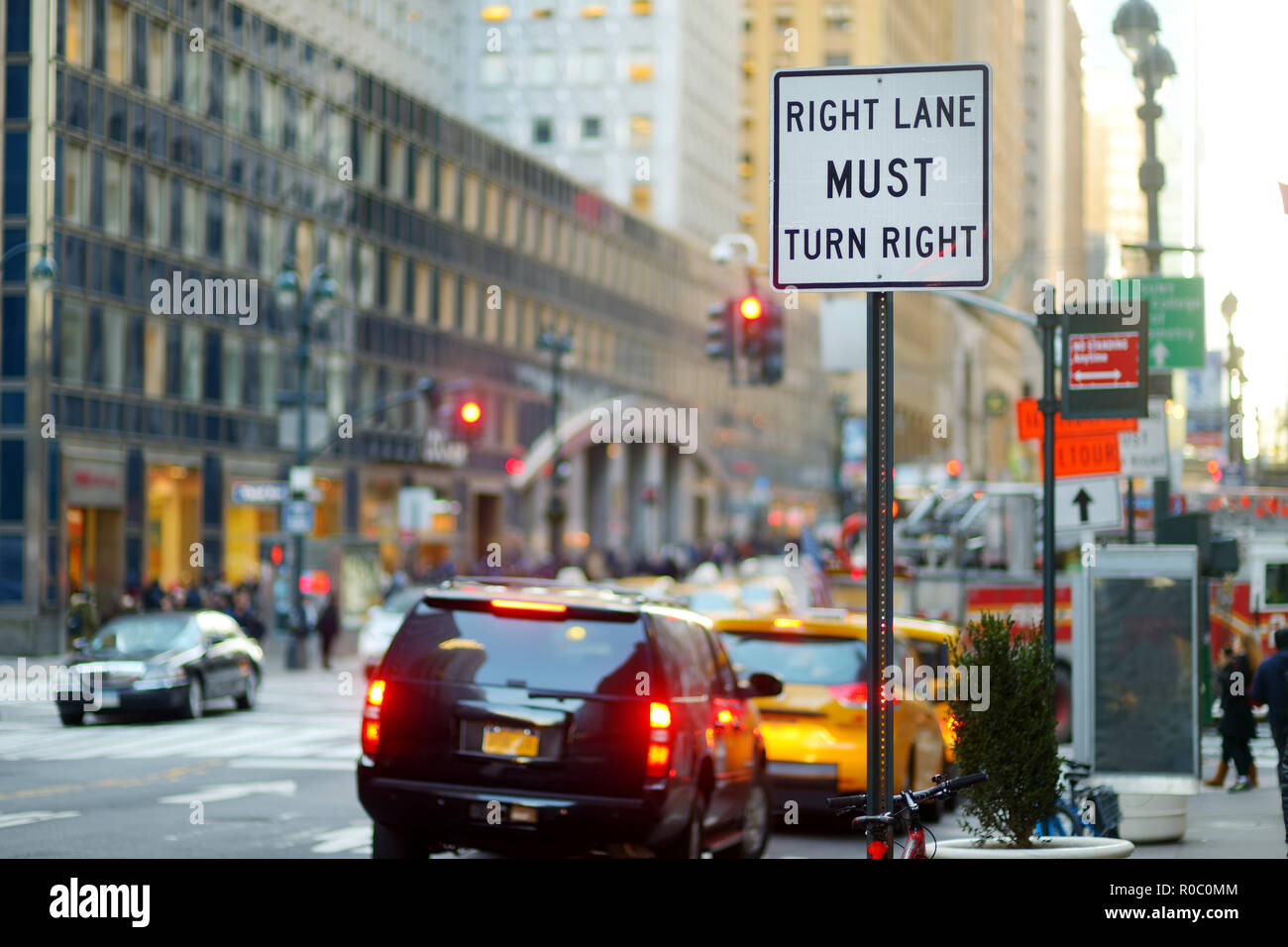Roadsign in New York. Cars, taxi cabs and people rushing on busy ...