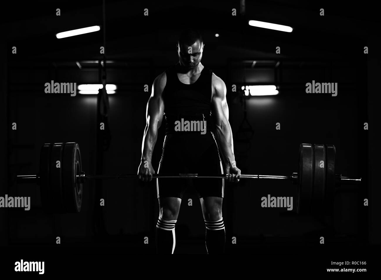 Strong Man Lifting Heavy Barbell From Floor During Powerlifting Workout ...