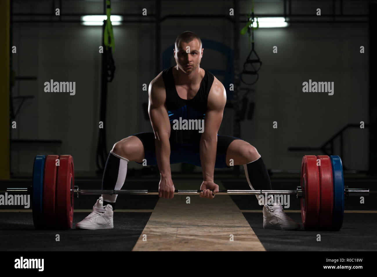 Athlete Is Standing on His Knee and Near the Bar in the Gym and Is ...