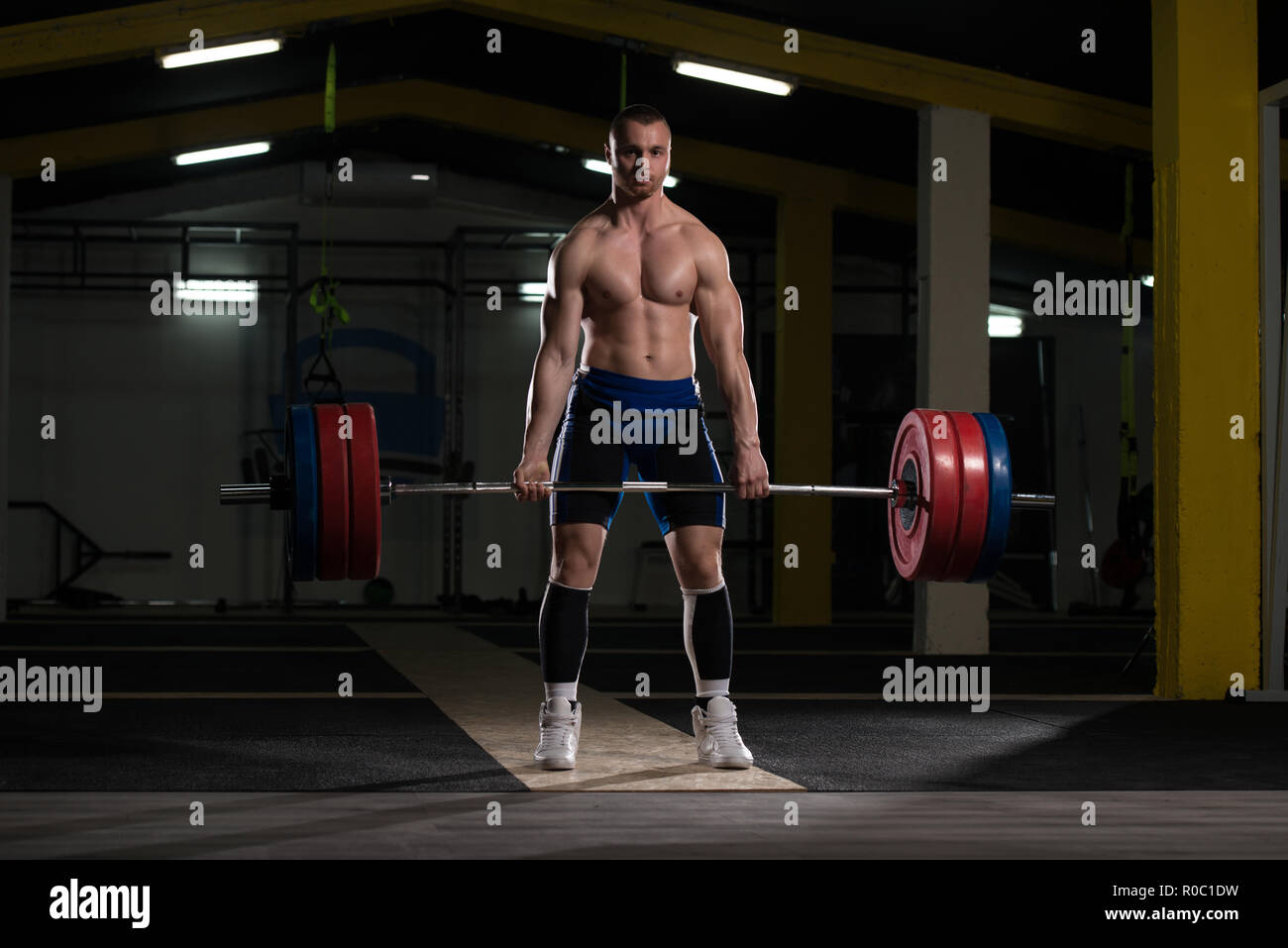 Strong Man Lifting Heavy Barbell From Floor During Powerlifting Workout ...