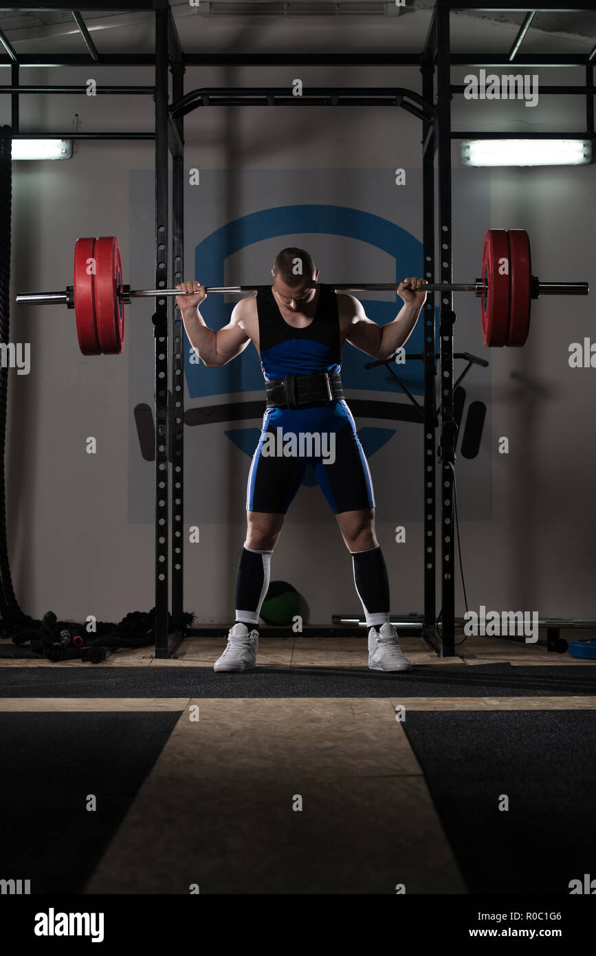 Powerlifter Working Out Legs With Barbell In A Gym - Squat Exercise ...