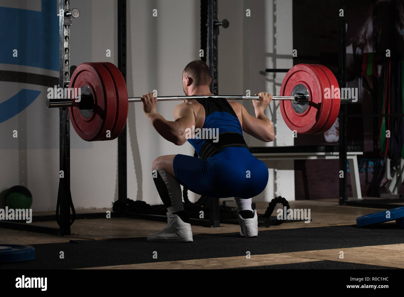 Powerlifter Working Out Legs With Barbell In A Gym - Squat Exercise ...
