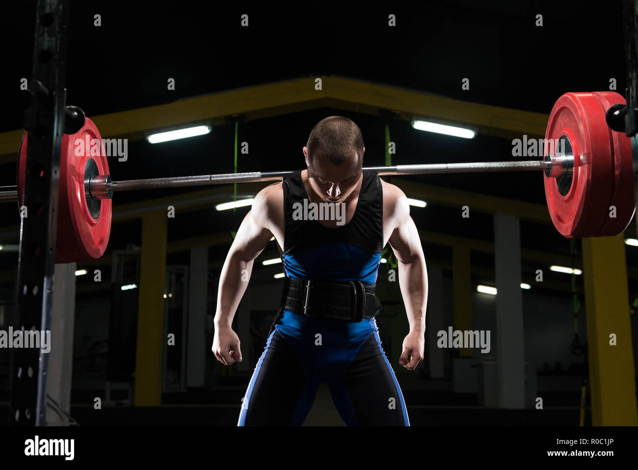 Powerlifter Working Out Legs With Barbell In A Gym - Squat Exercise ...