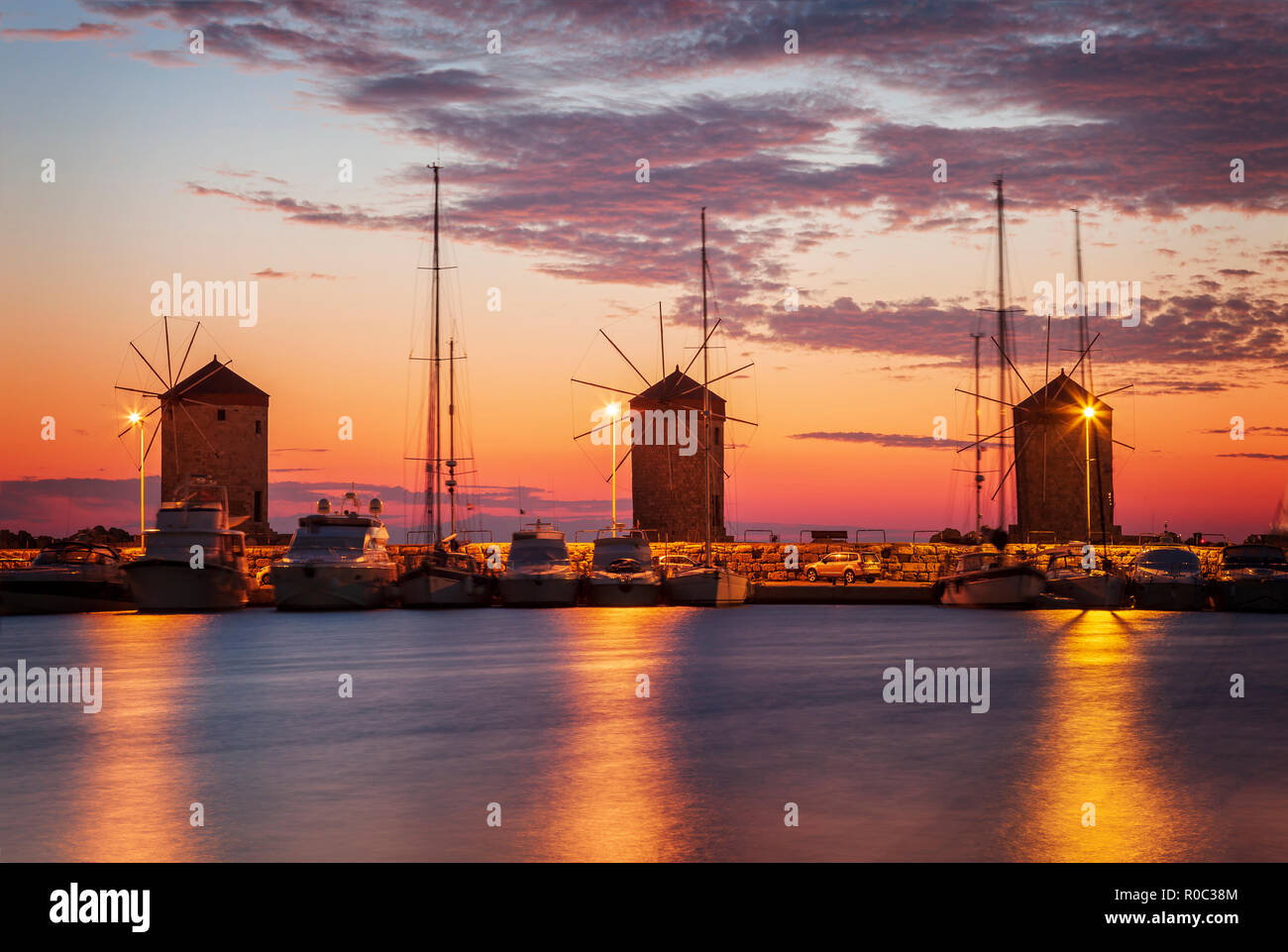 Windmills on the harbour pier. Rhodes town, Greece Stock Photo - Alamy