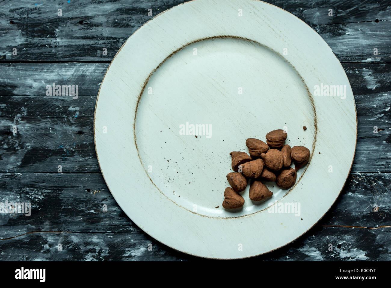 sweet, chocolate truffles and bitter cocoa on a white plate and dark ...
