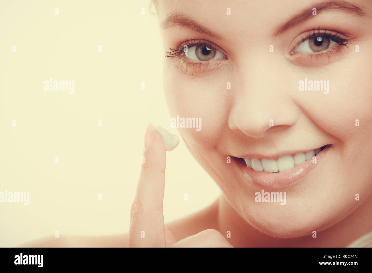 Beauty treatment. Woman applying moisturizing cream skin care product ...