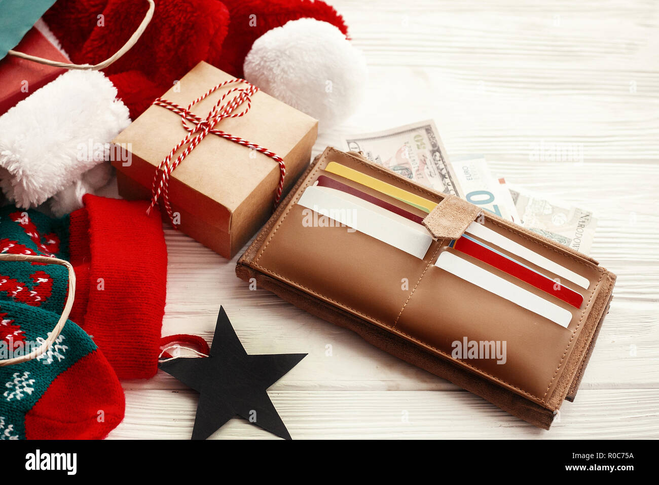 Credit cards and money in wallet, paper bags with clothes, stockings ...