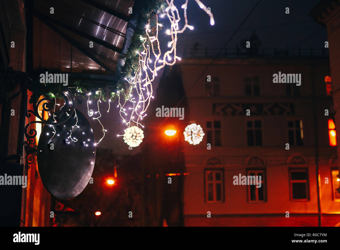 Stylish christmas decorations, garland lights on window of cafe or ...