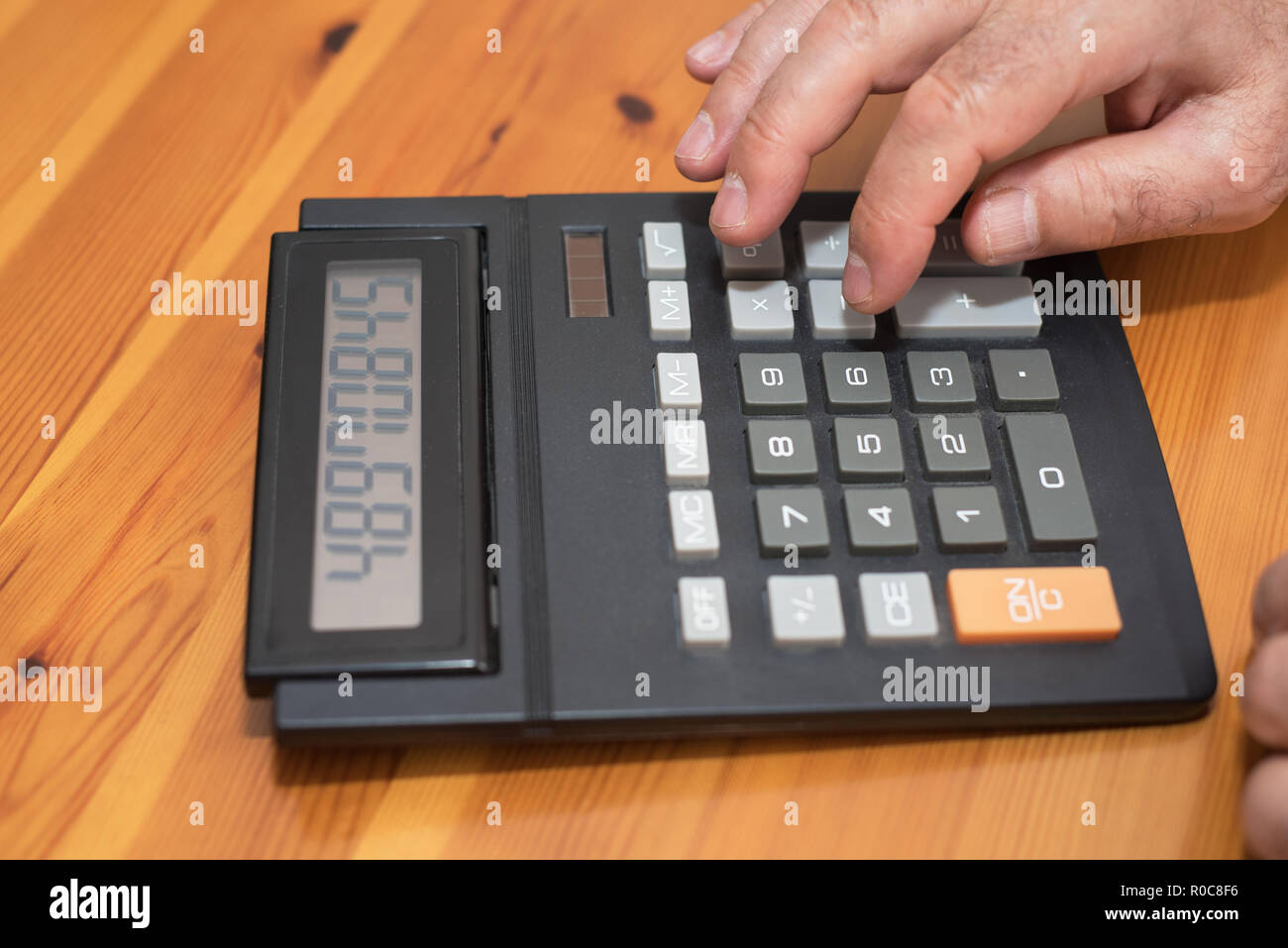 Man using calculator, calculating bills at home Stock Photo - Alamy