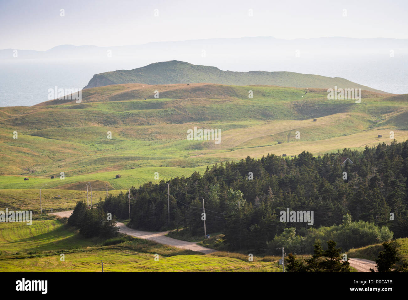 A road winds its way through the rolling fields in the Magdalen Islands ...