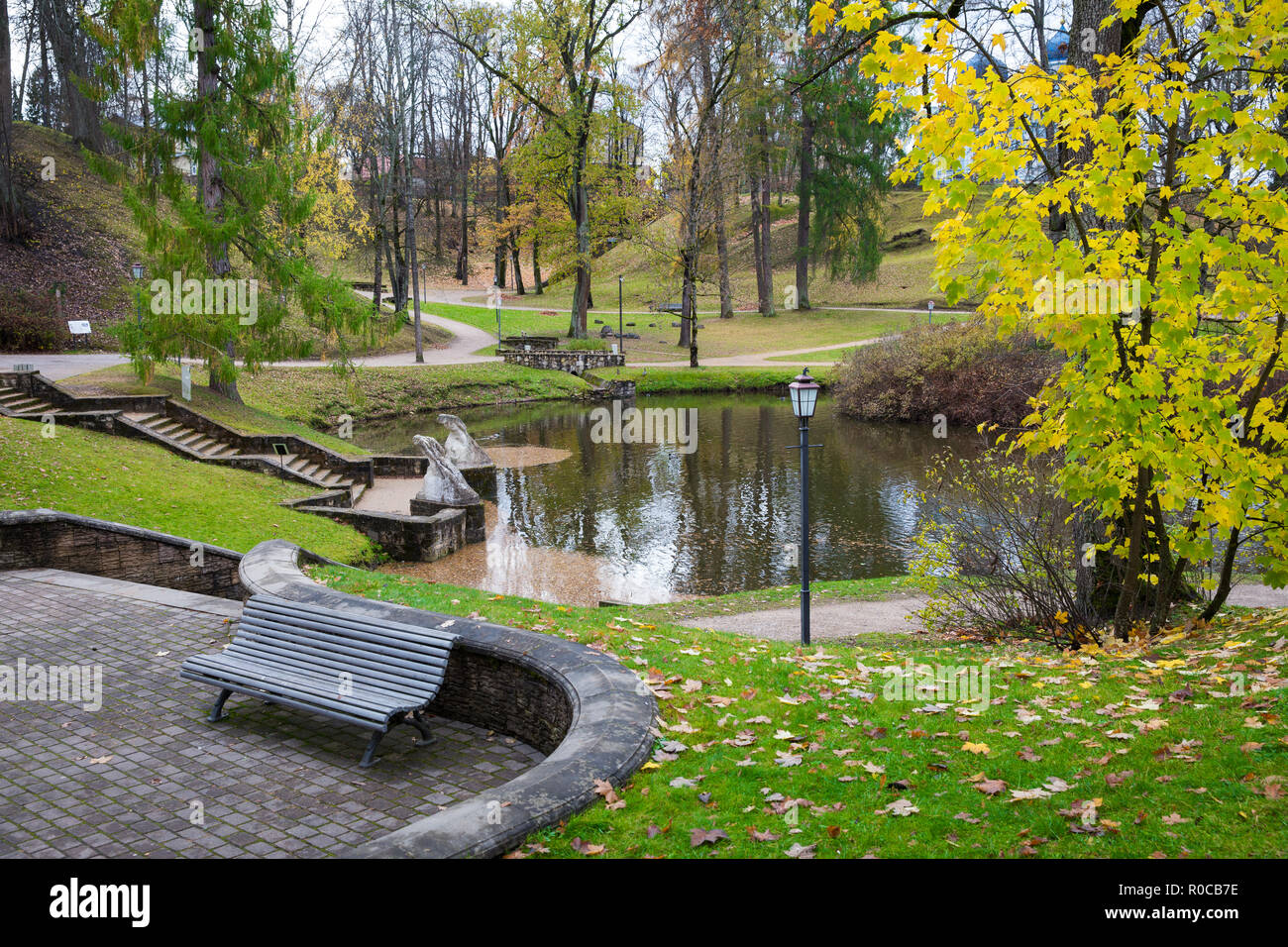 City Cesis, Latvia. Old park at autumn. Yellow leafs and architecture ...
