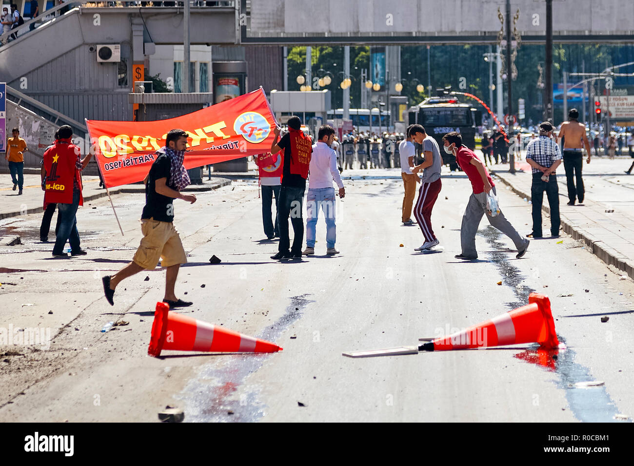 Protesters carrying a banner trying to stand against the police water ...