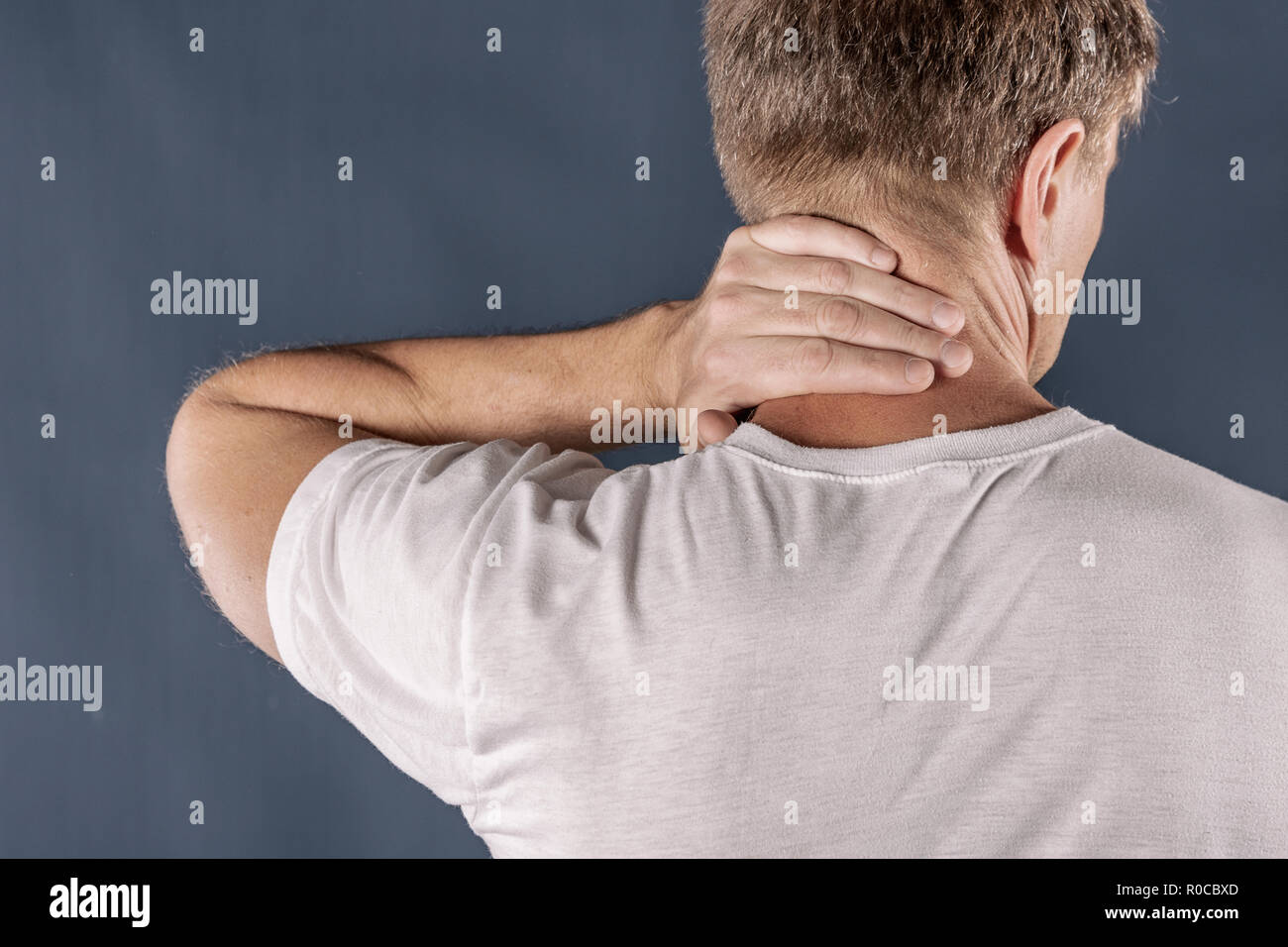 Man holding his neck trying to relieve pain Stock Photo - Alamy