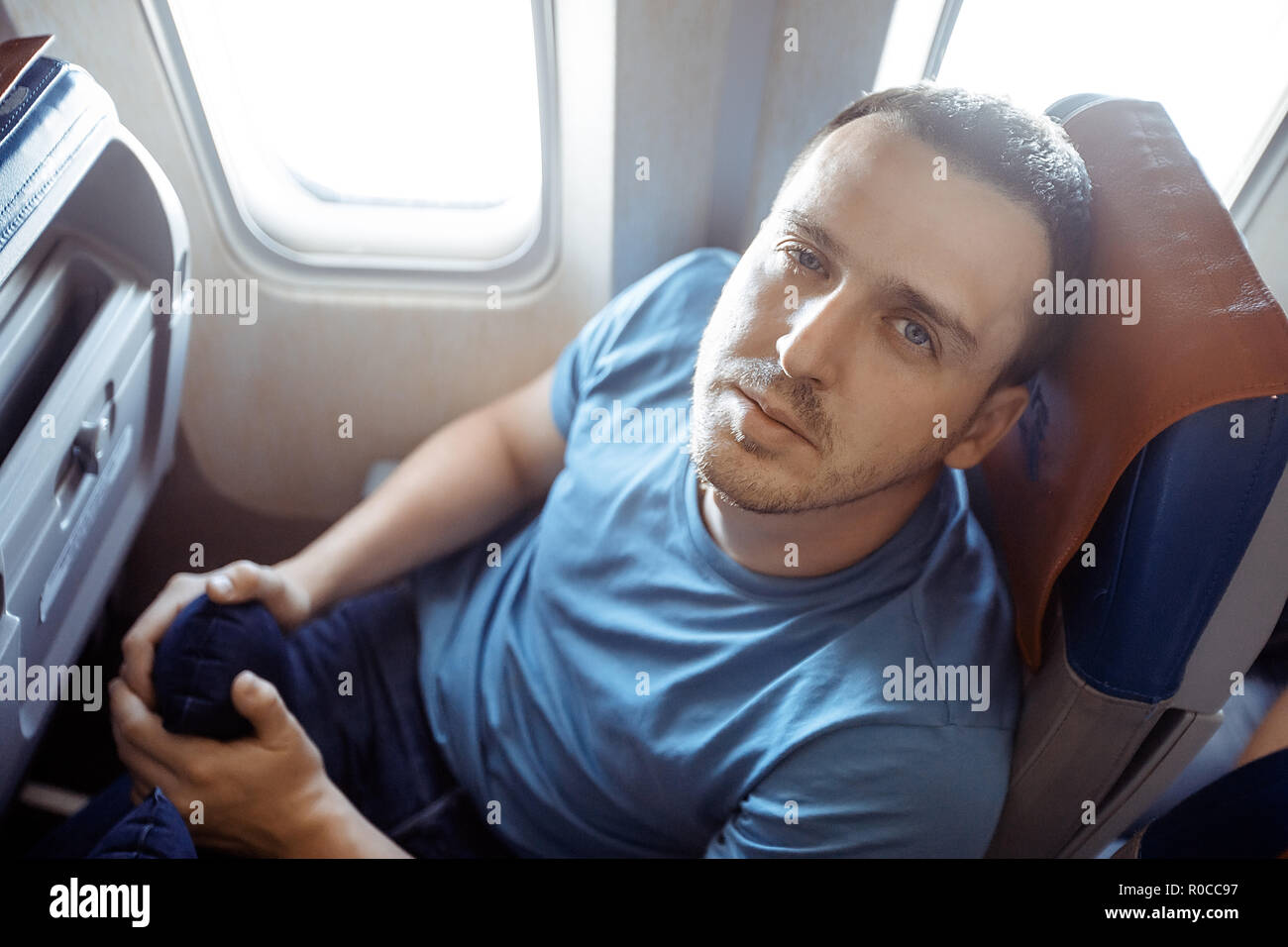 Tired man on the plane Stock Photo - Alamy