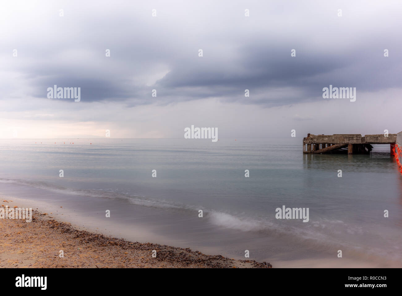 An abandoned pier on the Tuscan sea in Autumn at sunset with long ...