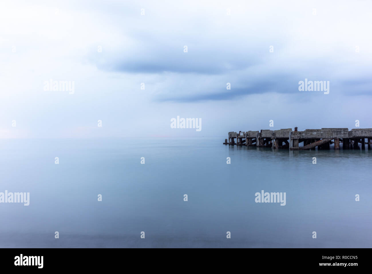 An abandoned pier on the Tuscan sea in Autumn at sunset with long ...