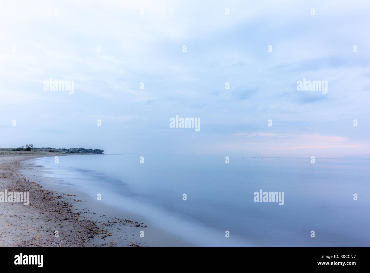 An abandoned pier on the Tuscan sea in Autumn at sunset with long ...