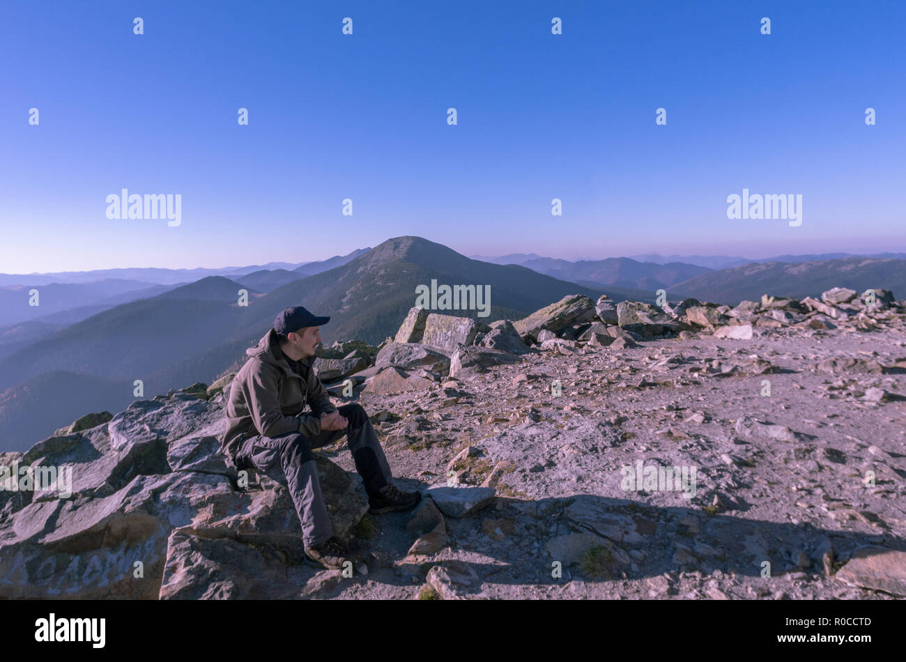 A man on top of a mountain. A man looks into the distance. Tourist at ...