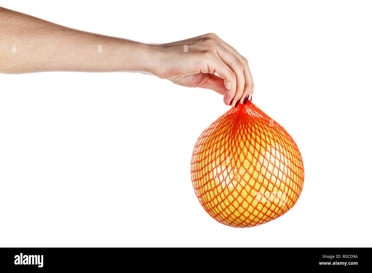 whole citrus pomelo in a grid in a female hand on a white background ...