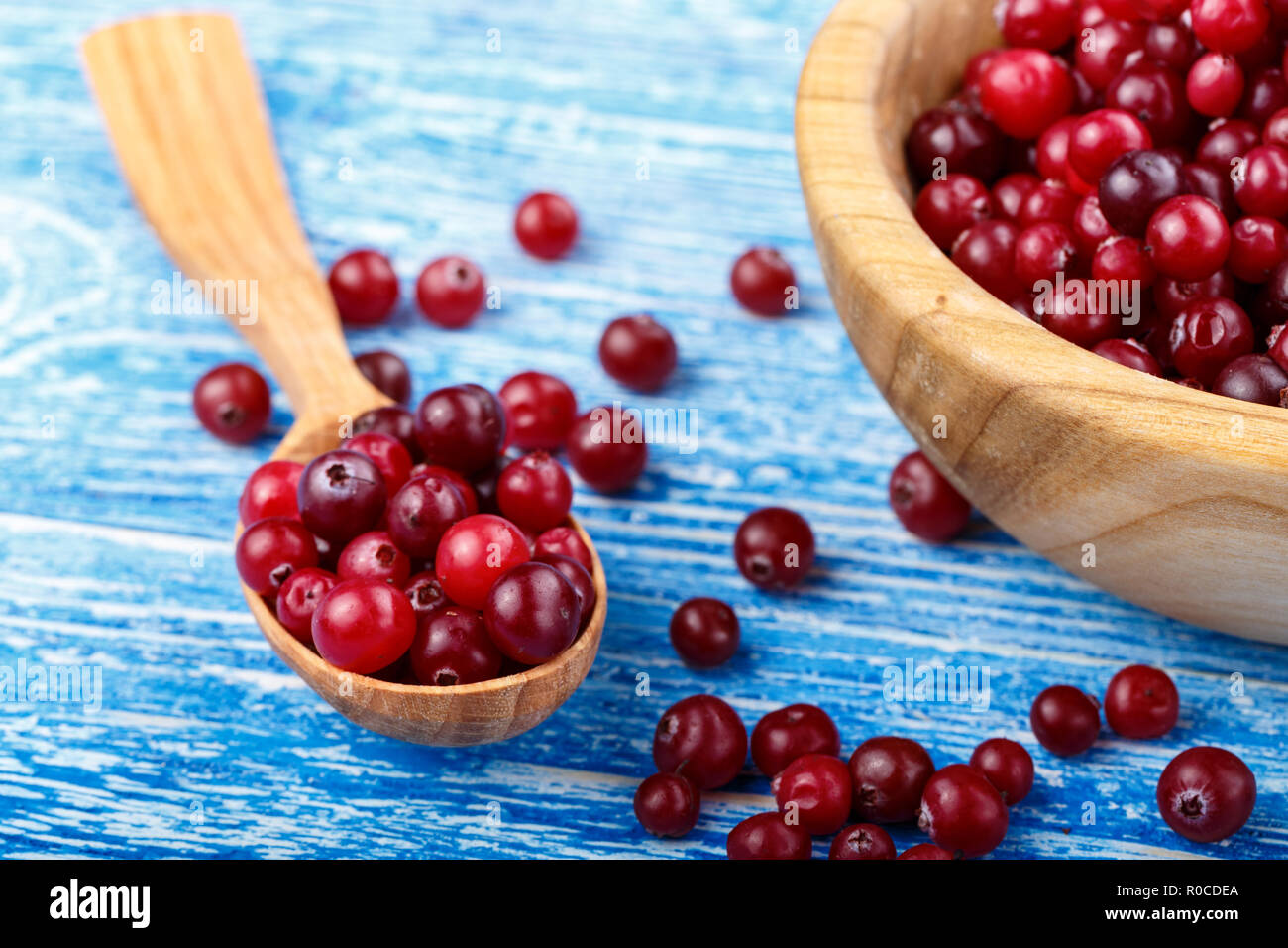Raw cranberries in a wooden plate on a wooden background. space for ...