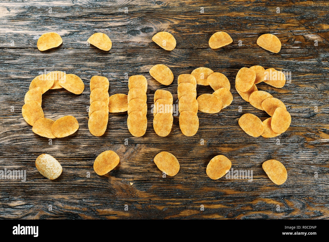 potato chips on wooden background. chips laid out the inscription Chips ...