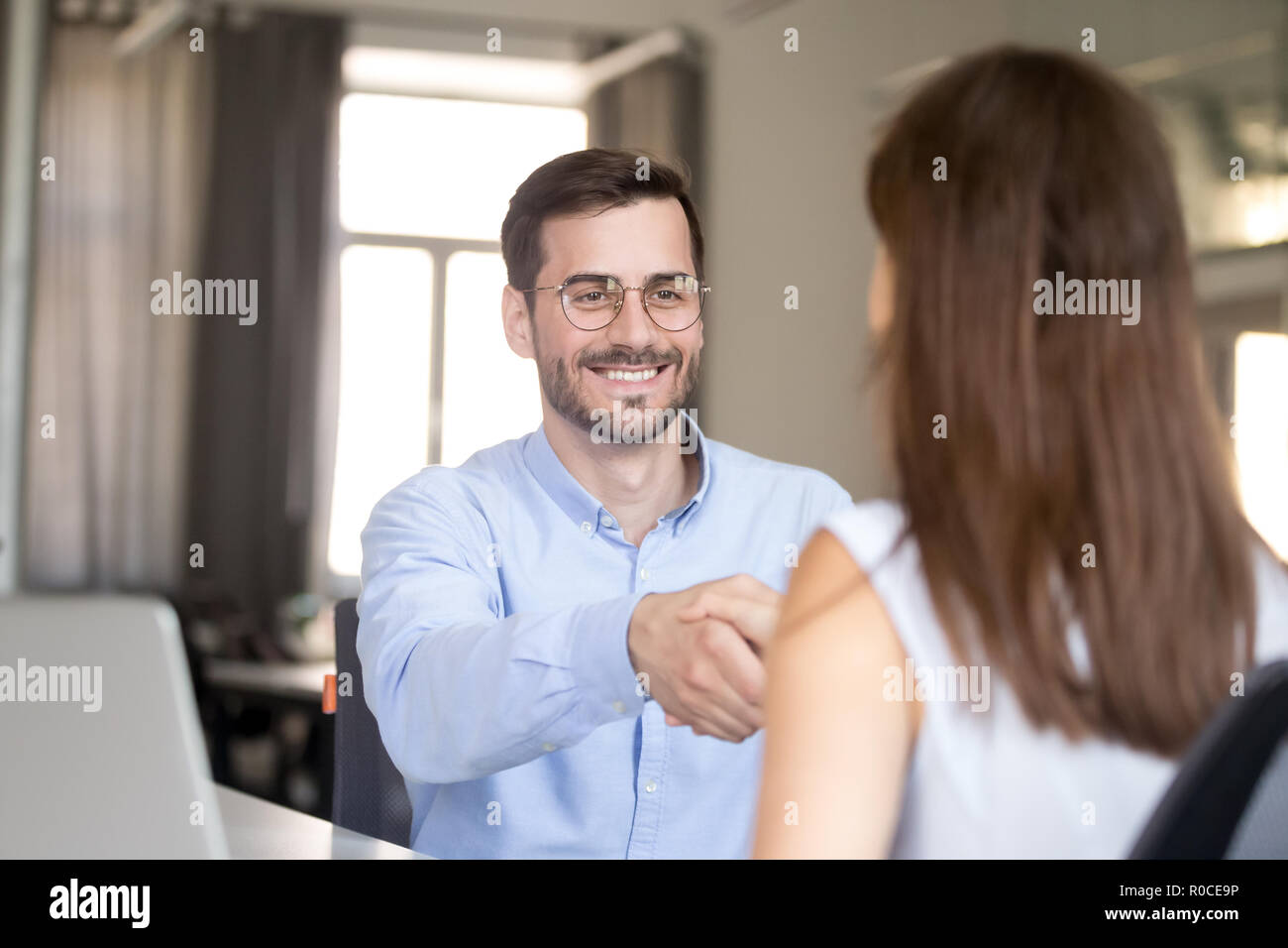 Smiling friendly businessman handshaking woman at job interview Stock ...