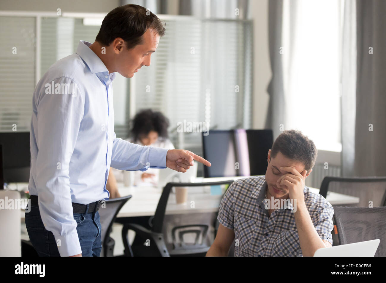 Angry boss scolding rebuking incompetent male office worker at w Stock ...