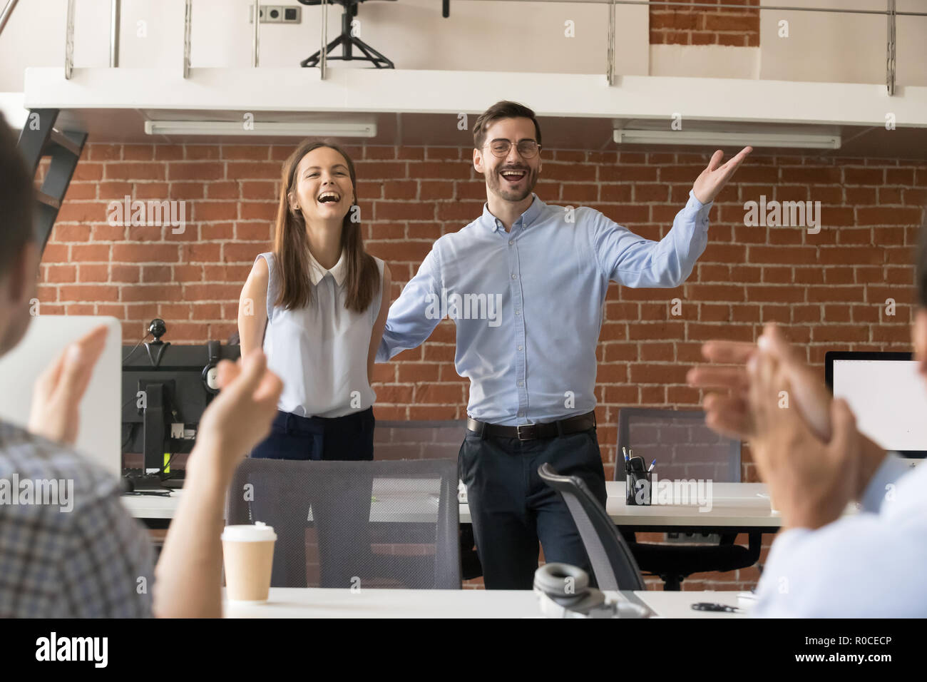 Excited team leader congratulating employee with promotion while Stock ...