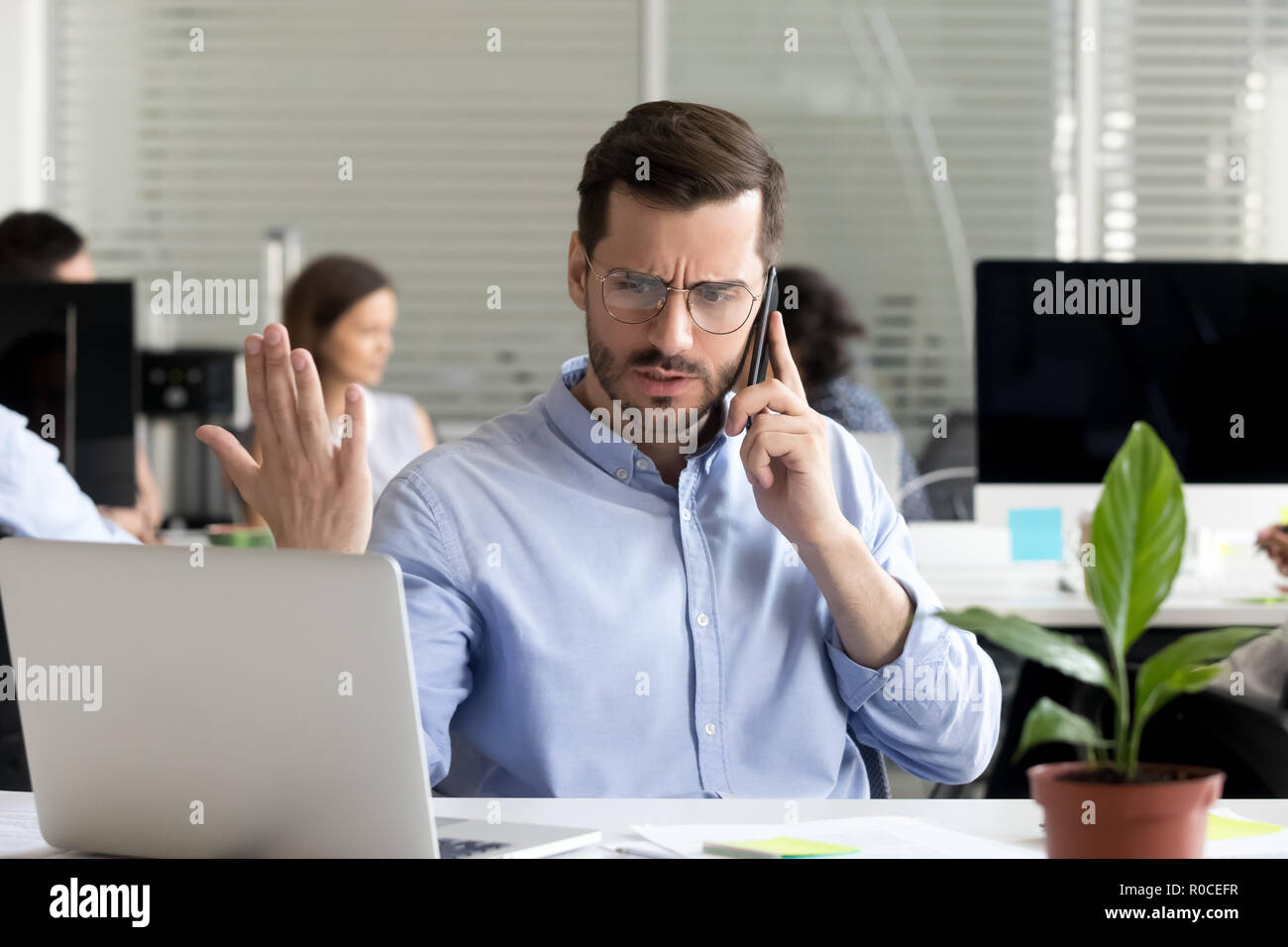 Angry businessman caller talking on phone disputing over compute Stock ...